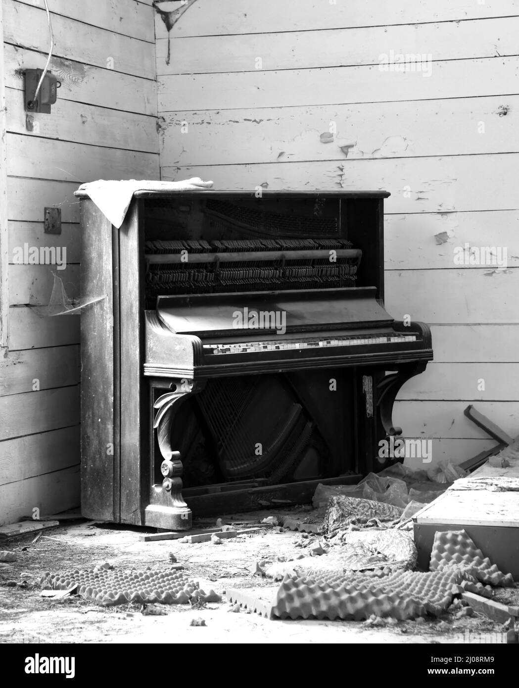 Old, abandoned church has antique piano covered in dust and cobwebs ...