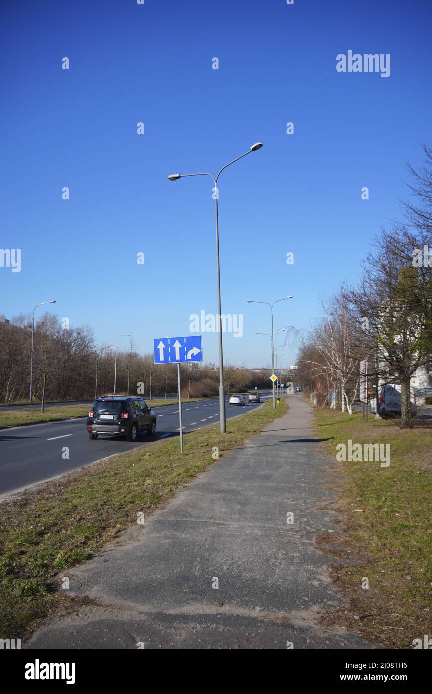Vertical shot of a footpath and a traffic road with driving cars during ...