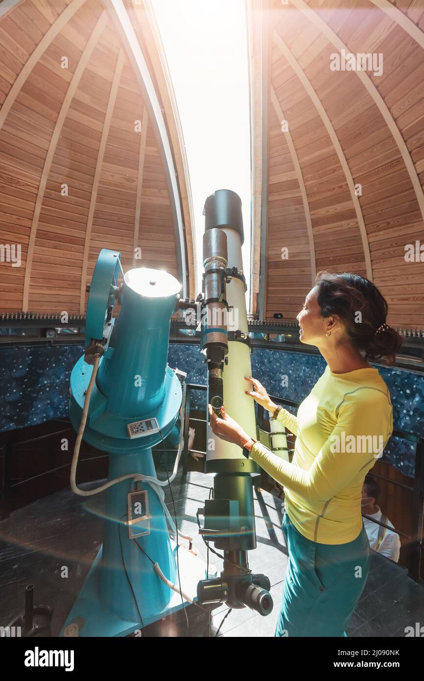 Happy woman in a space observatory looks at a meteorite or the sun ...
