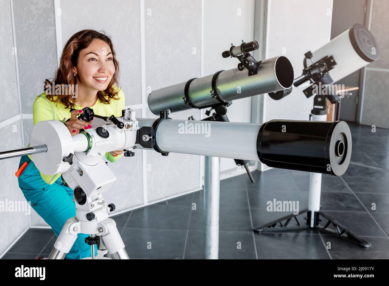 Happy woman in a space observatory looks at a meteorite or the sun ...