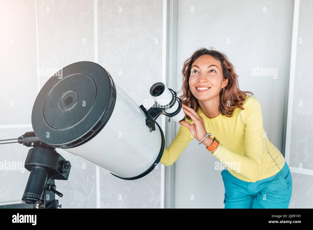 Happy woman in a space observatory looks at a meteorite or the sun ...