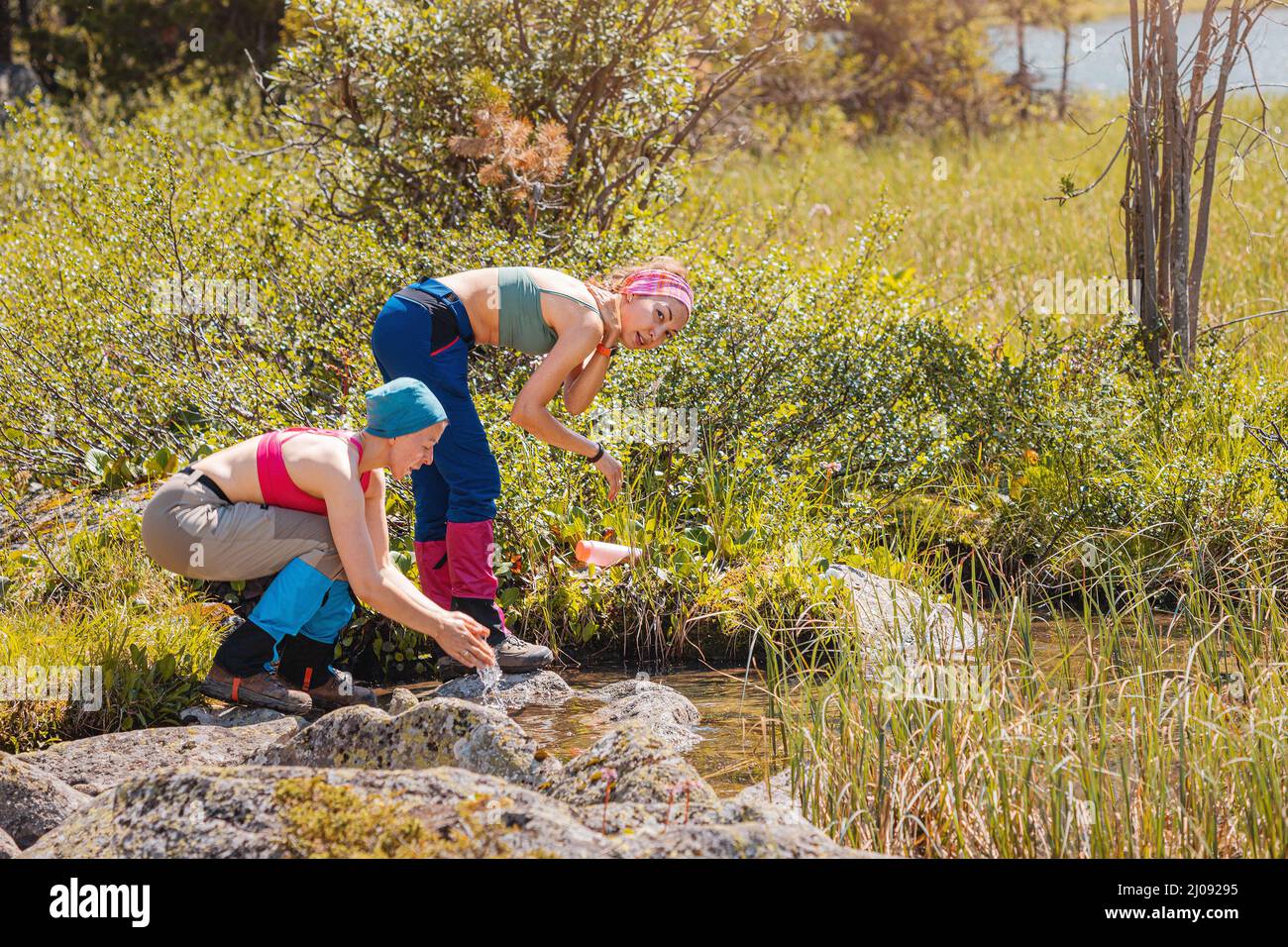 hygiene and refreshing while hiking in the wilderness. Two girls wash ...