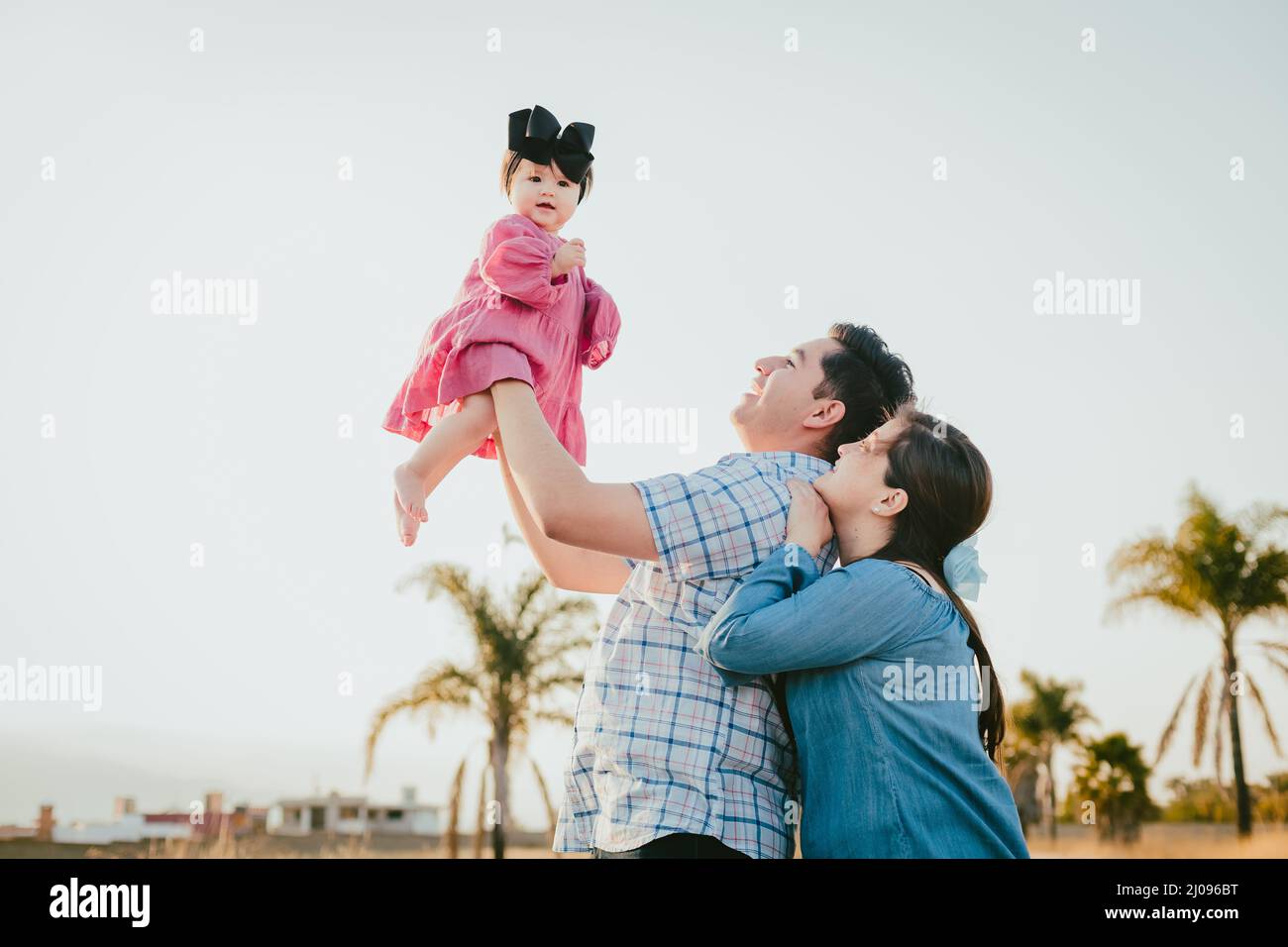 Hispanic family enjoying nature in the park - young parents with their ...