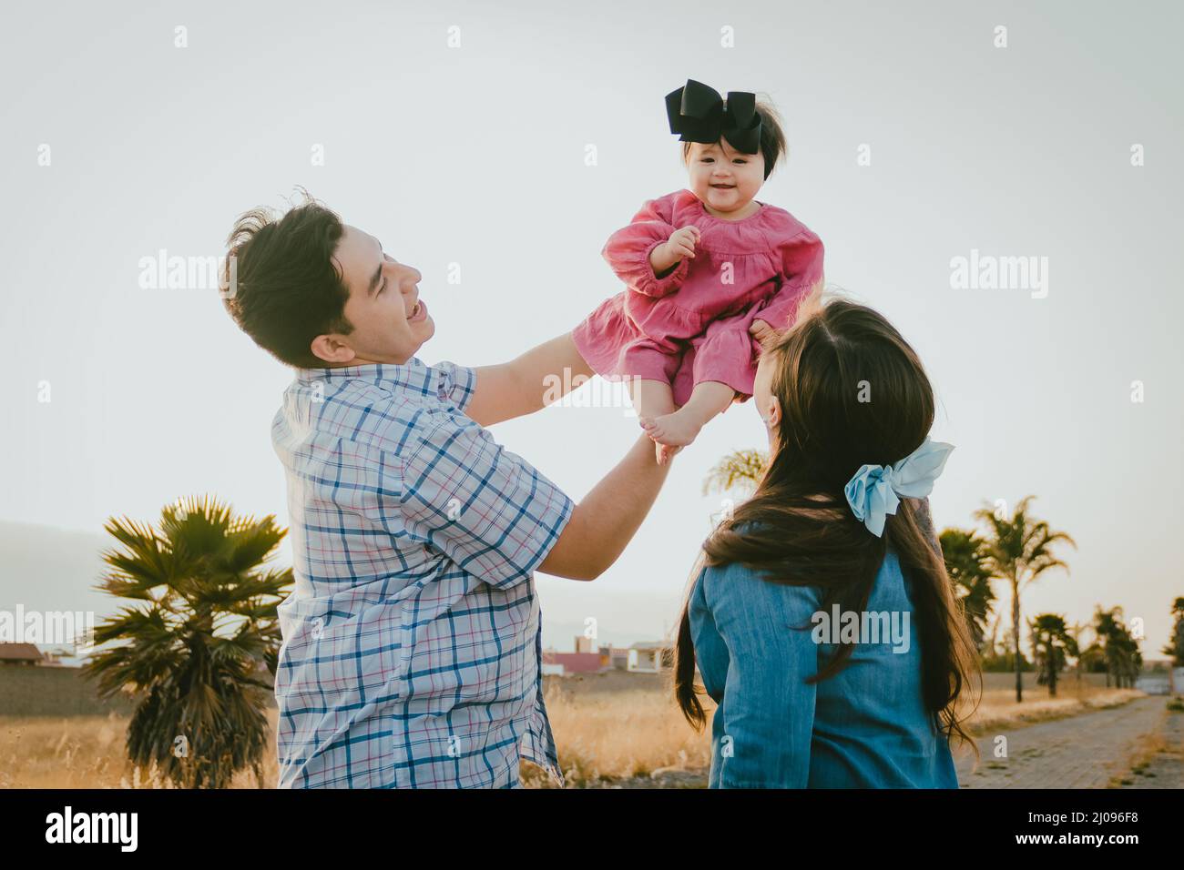 Hispanic family enjoying nature in the park - young parents with their ...