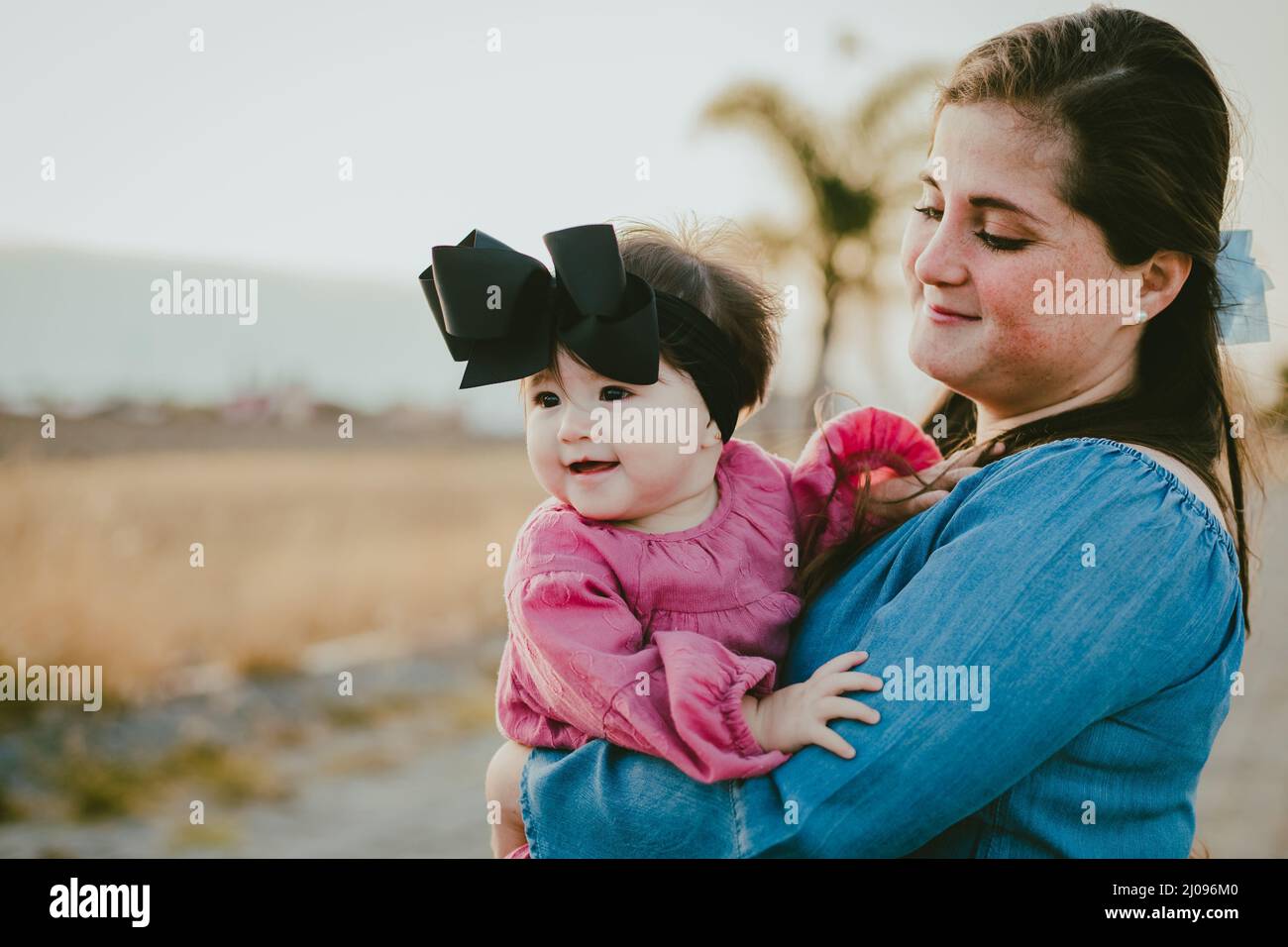 Hispanic family enjoying nature in the park - young parents with their ...