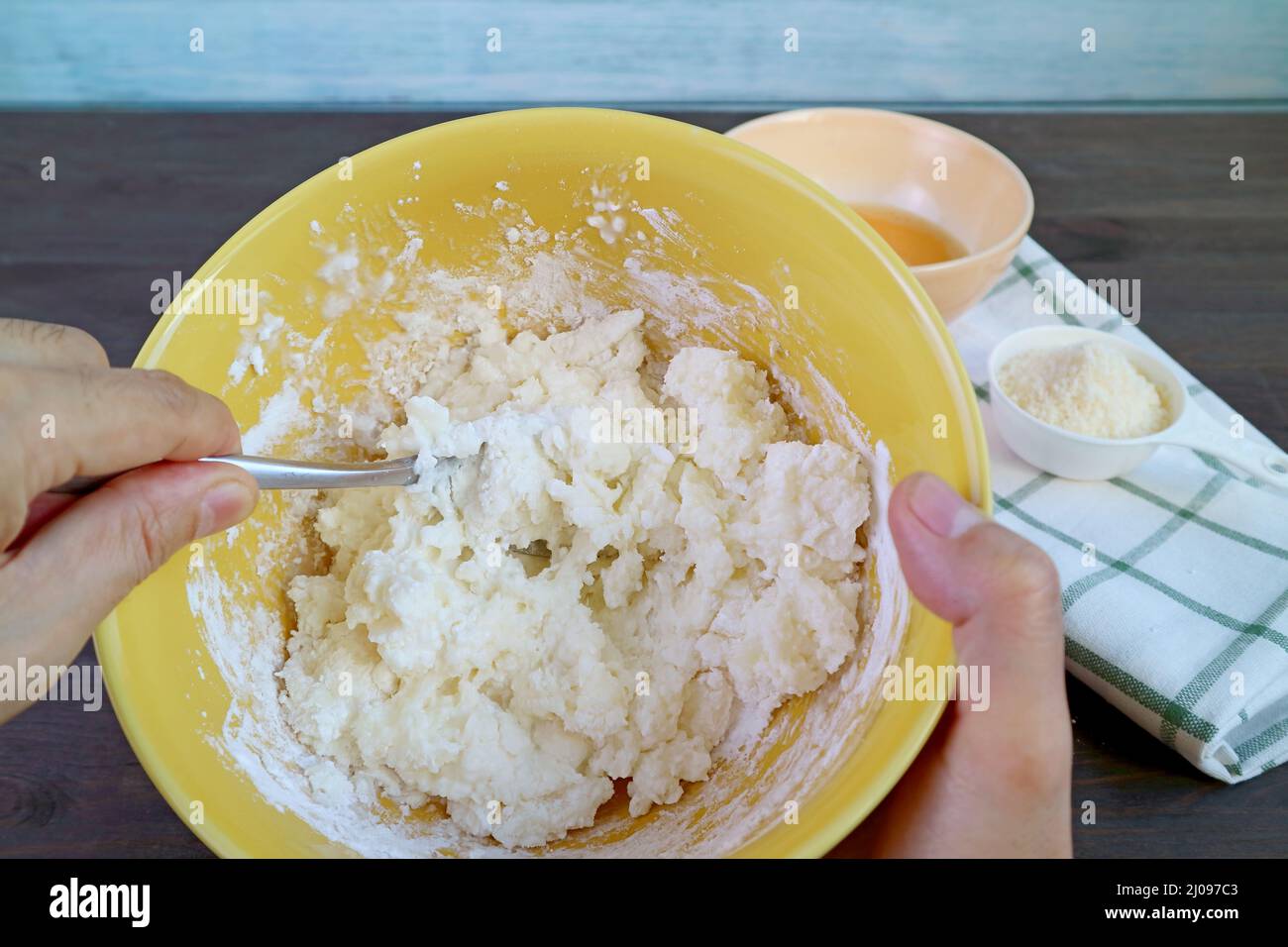 Hand mixing the mixture in a bowl with spoon for baking Brazilian ...