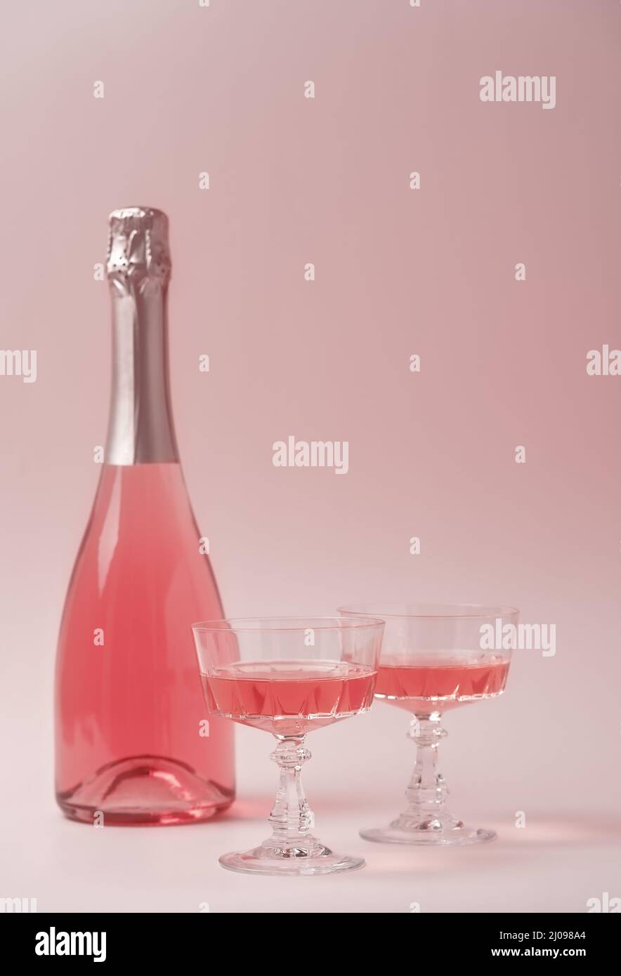 Two crystal glasses and bottle of rose sparkling wine or champagne on ... Two crystal glasses and bottle of rose sparkling wine or champagne on ...