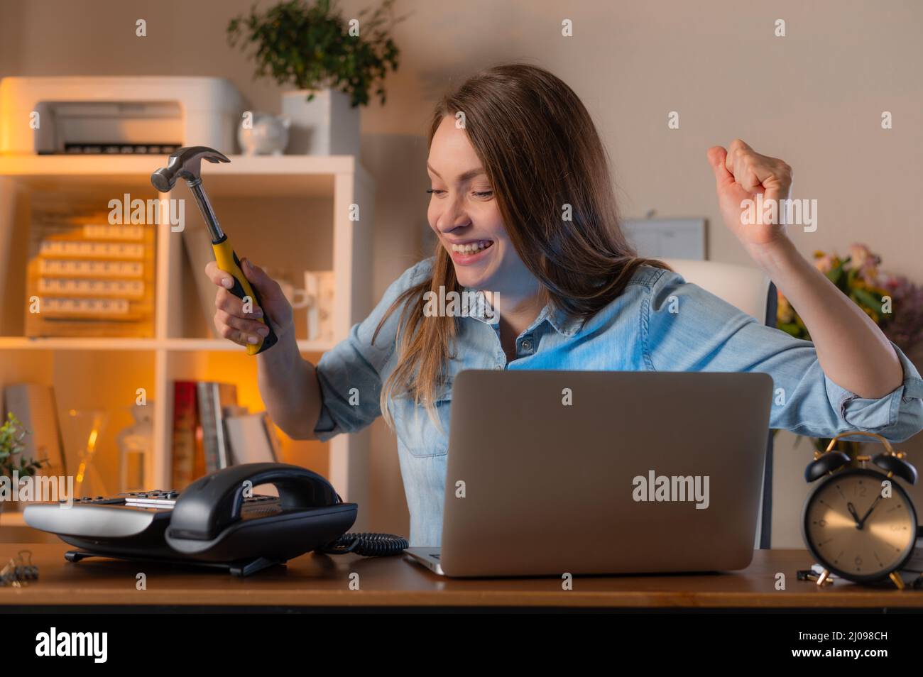 Emotional young woman siting at her workplace and breaks phone. Concept ...