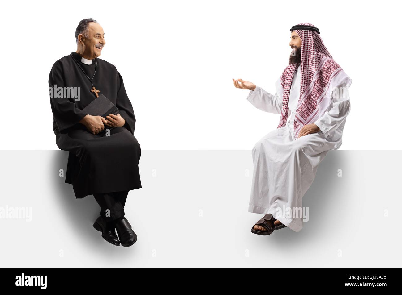Priest and a saudi arab man sitting on a blank panel and talking ...