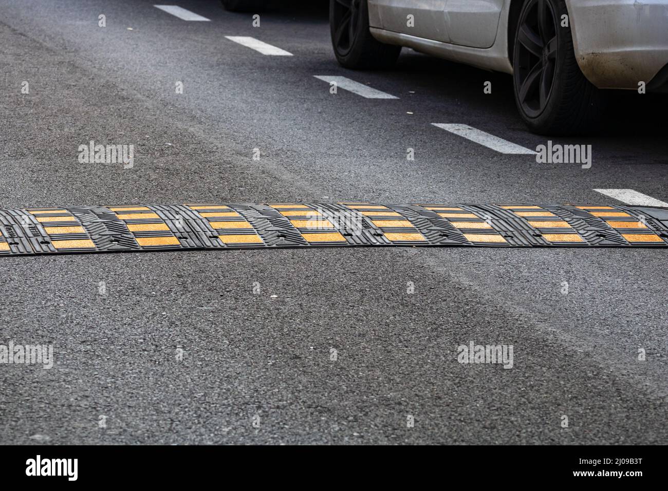Traffic safety speed bump on an asphalt road in a parking area in ...