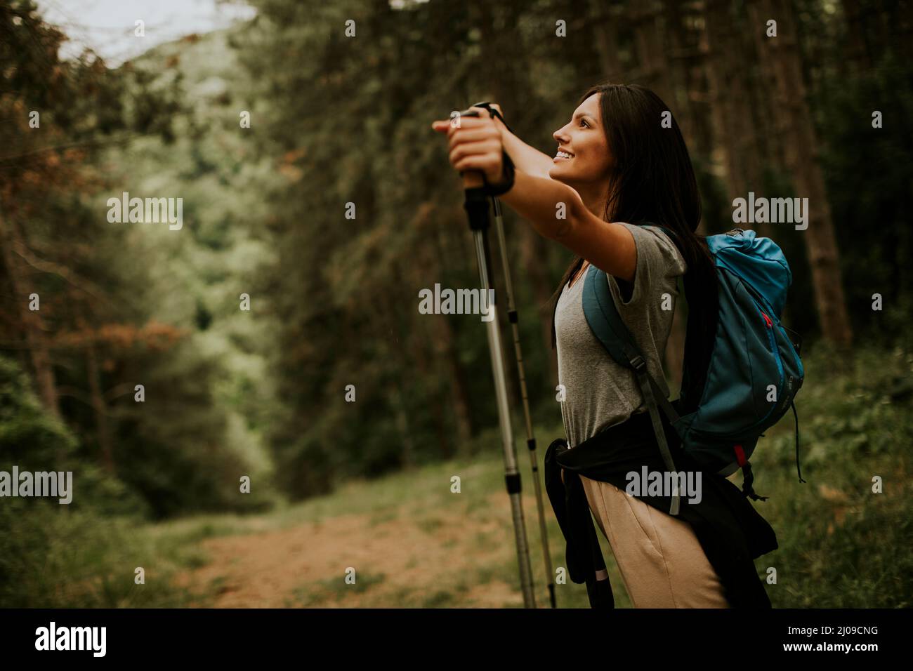 Pretty young female backpacker woman enjoying green beautiful forest ...