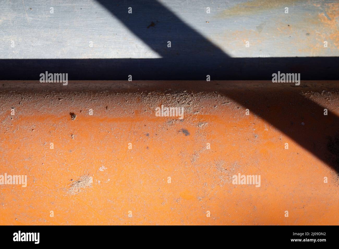 Sandy background, orange and grey painted colored and shaded surface ...