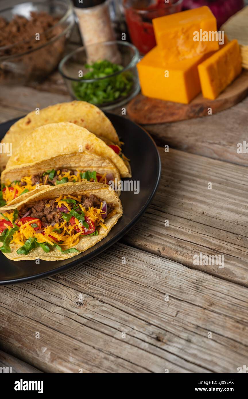 Side view of plate with tasty mexican tacos on rustic wooden table with ...