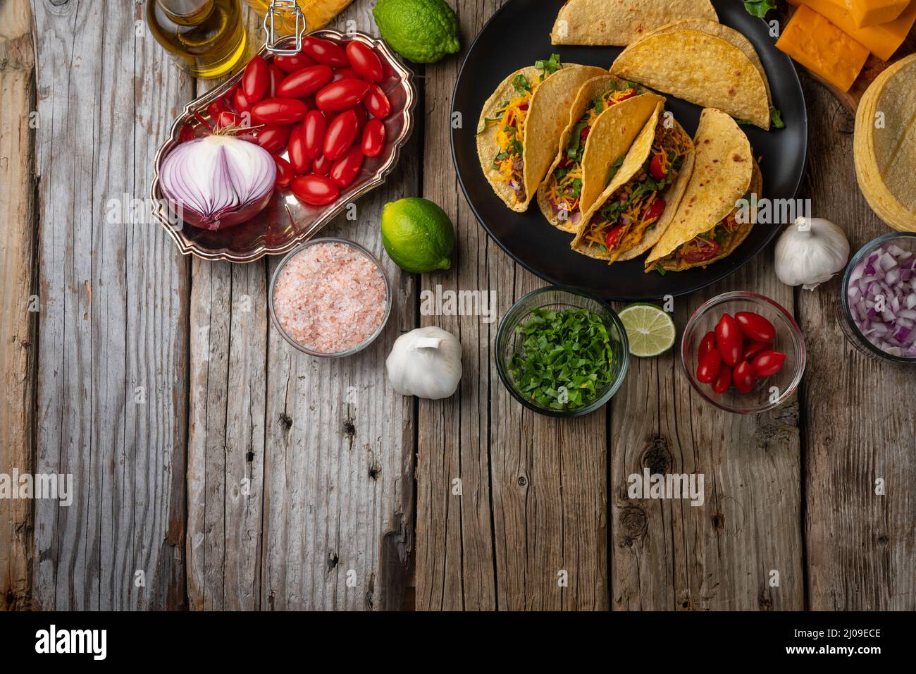 Plate with hot mexican tacos on rustic wooden table with ingredients ...