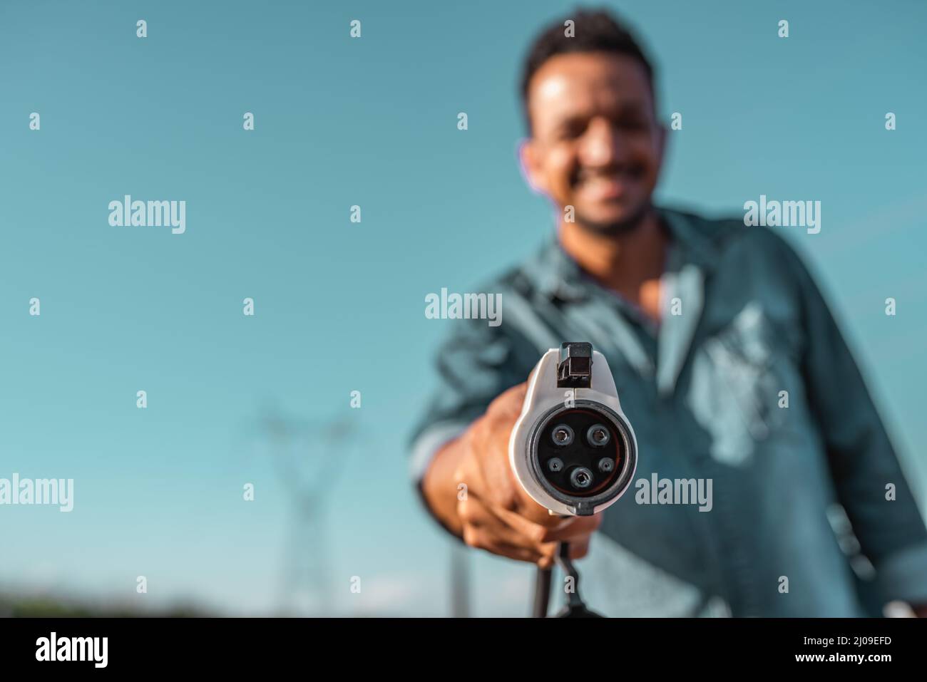 Human hand is holding electric car charging connect to electric car ...