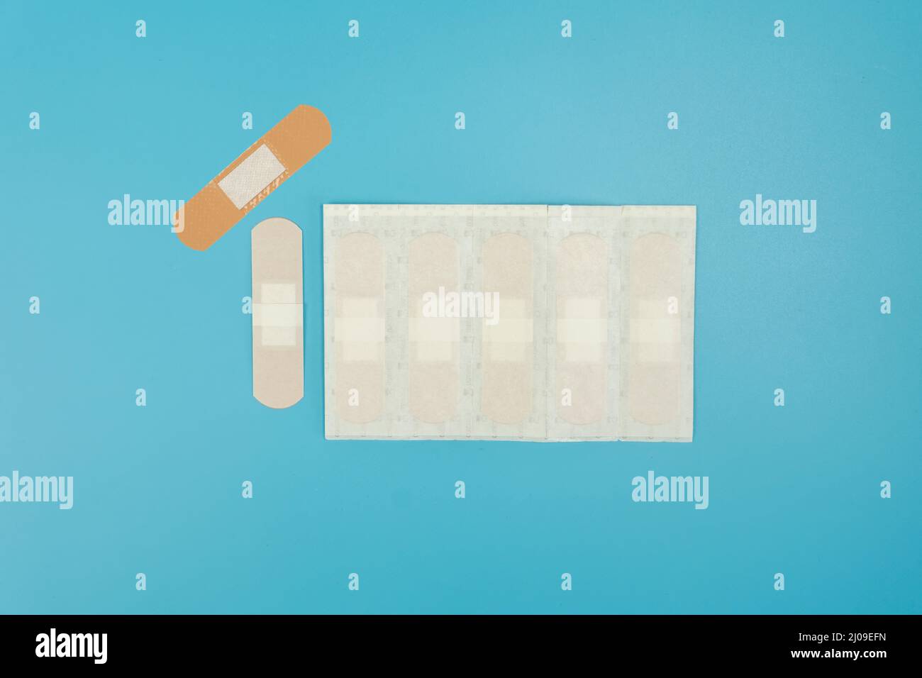 First aid sore plaster blue colored surface Stock Photo - Alamy
