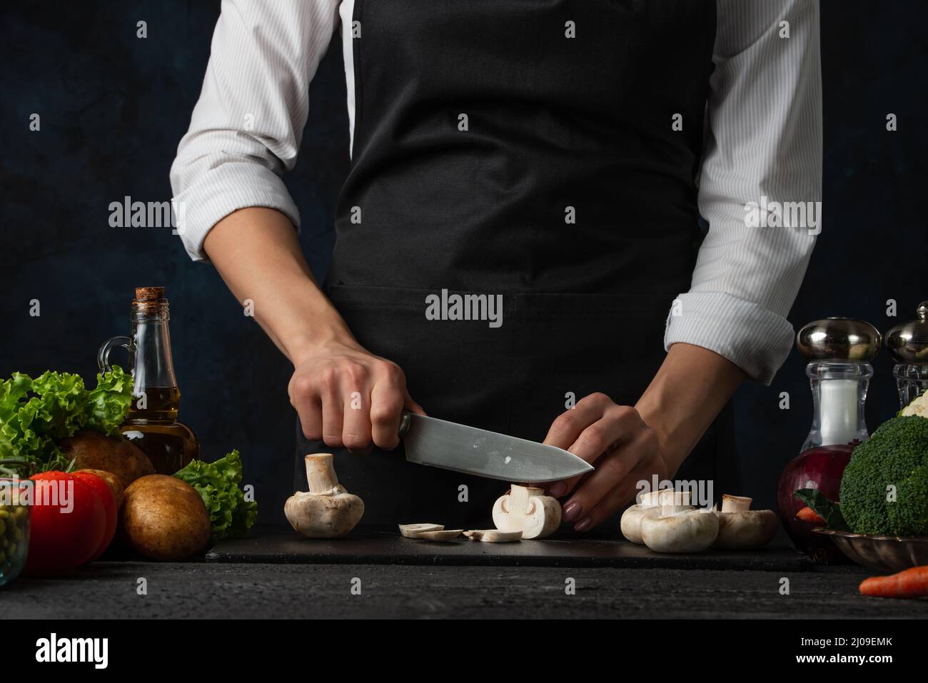 Macro shot view of chef cuts with knife mushrooms on chopped board for ...