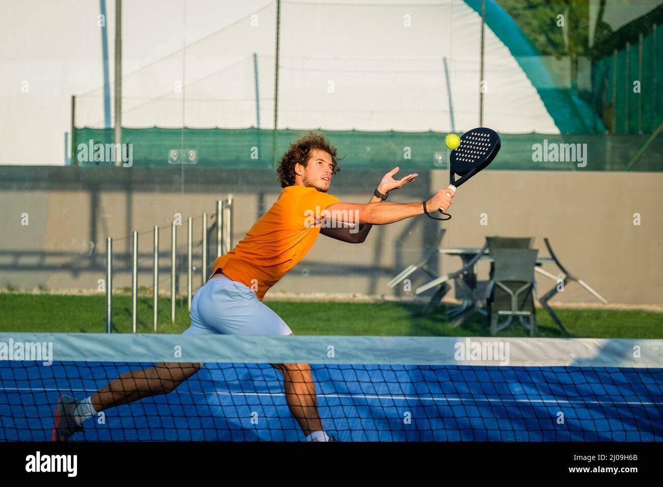 Padel match in a blue grass padel court - Padel player playing a match ...