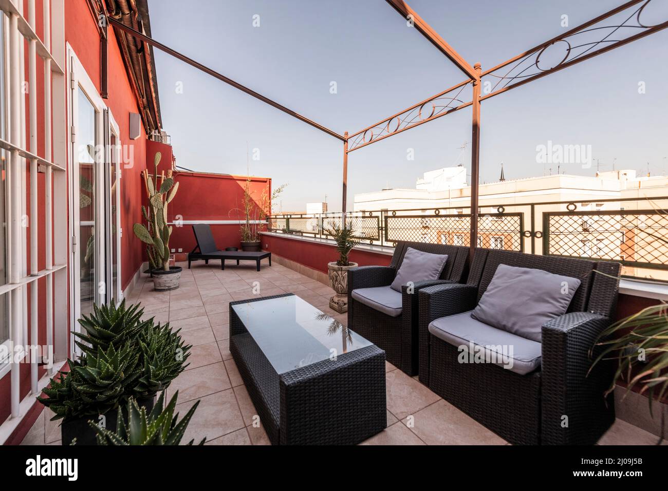 urban terrace of a residential penthouse with plants and wicker ...
