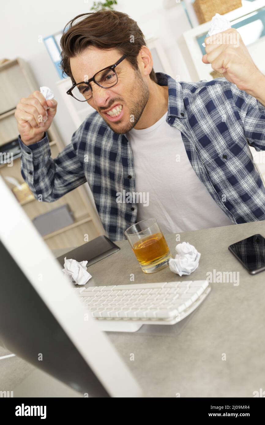 angry man with fists clenched at his computer Stock Photo - Alamy