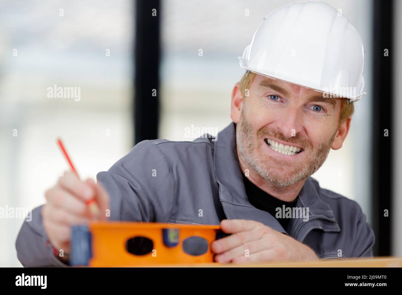 happy smiling constructor holding tool Stock Photo - Alamy