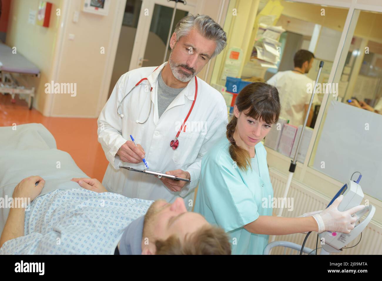 doctor with clipboard questioning patient Stock Photo - Alamy