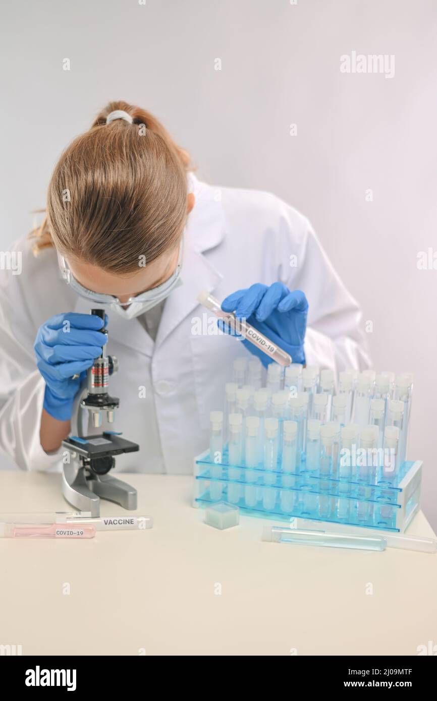Close-up view of female microbiologist in biohazard protective clothing ...