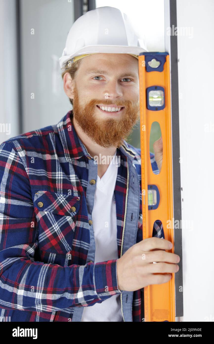 vertical image of workman using a spirit level Stock Photo - Alamy