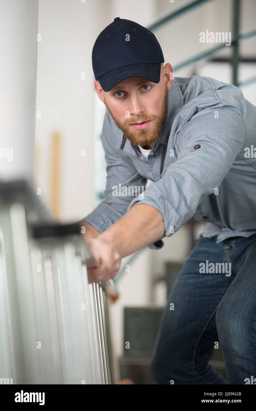 a man working with ladders Stock Photo - Alamy