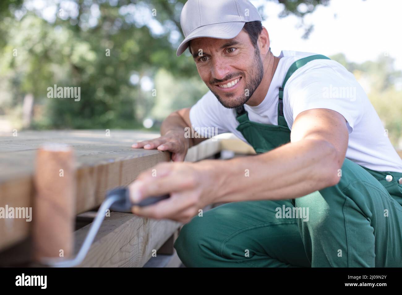 handsome young man carpenter installing a wood floor outdoor Stock ...