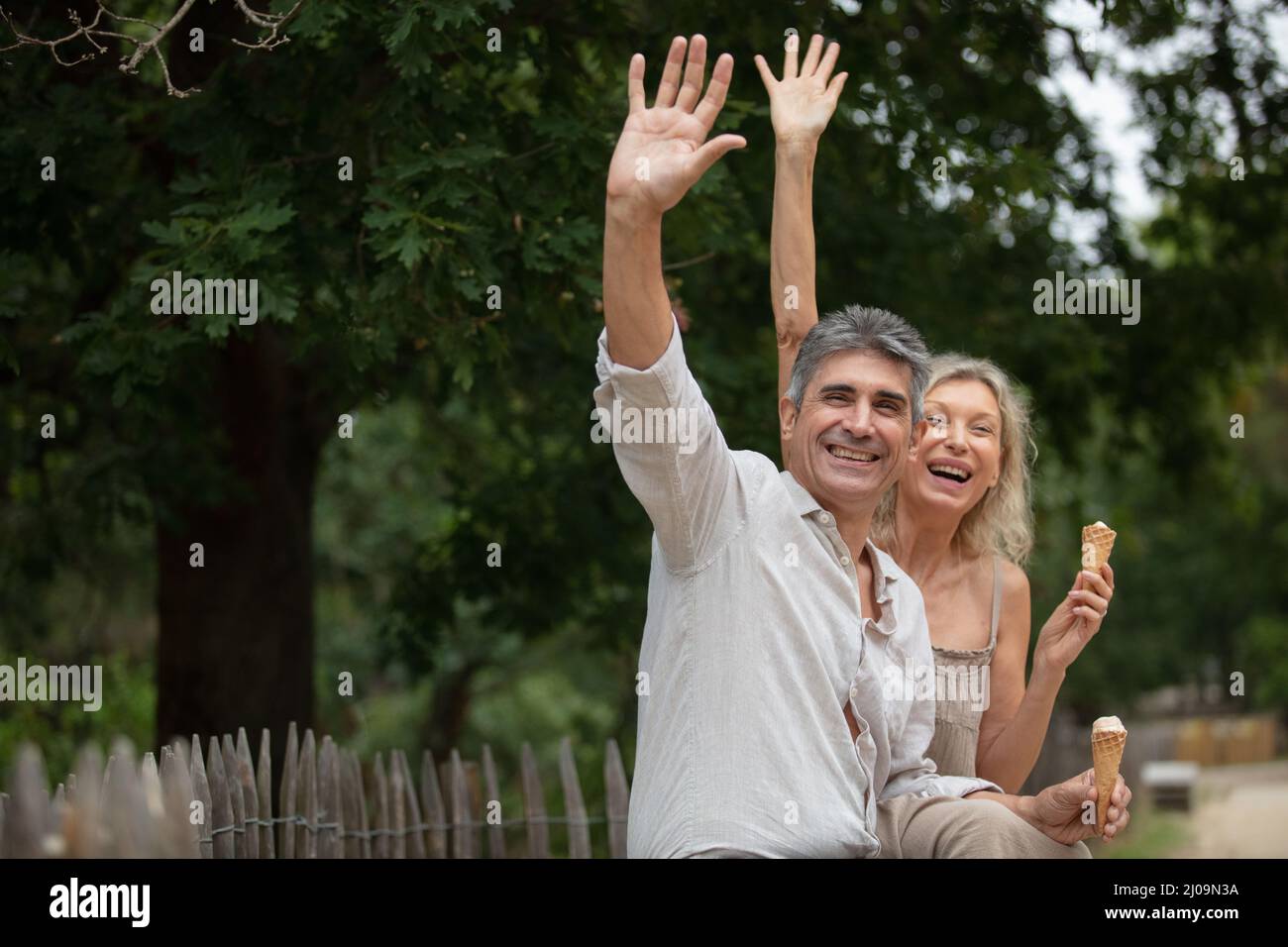 retired couple are smiling waving a hand Stock Photo - Alamy