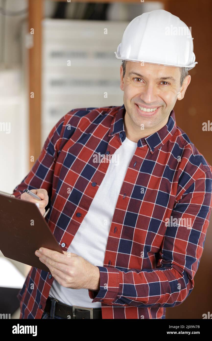 senior engineer wearing a safety-helmet and holding a clipboard Stock ...