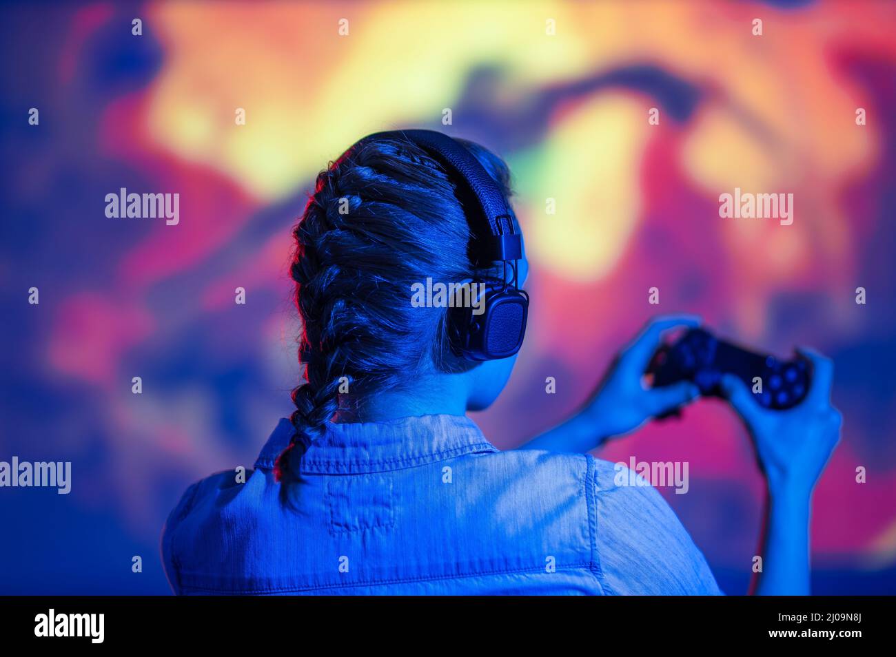 Close-up view from back of gamer woman playing video game at home in ...