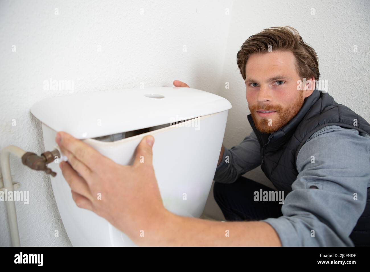 man is fixing the clog up toilet Stock Photo - Alamy