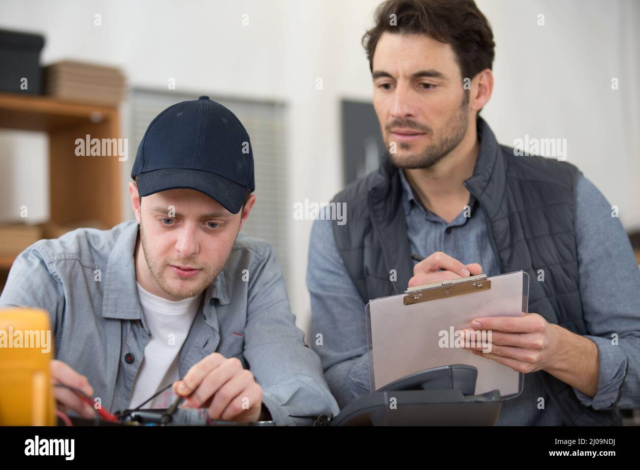 an apprentice electrician and his tutor Stock Photo - Alamy