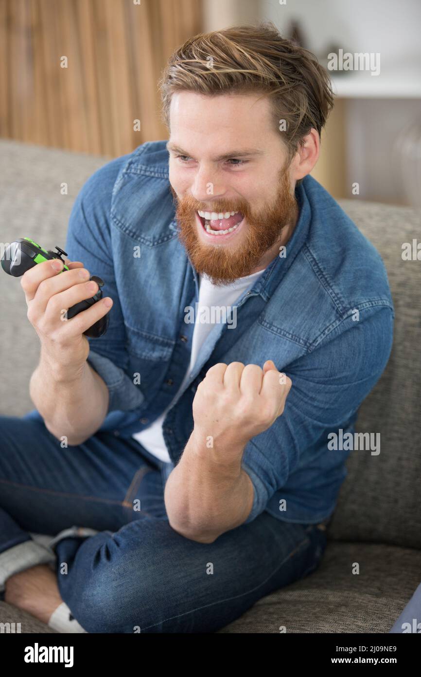 happy man concentrated playing video games with video game controller ...