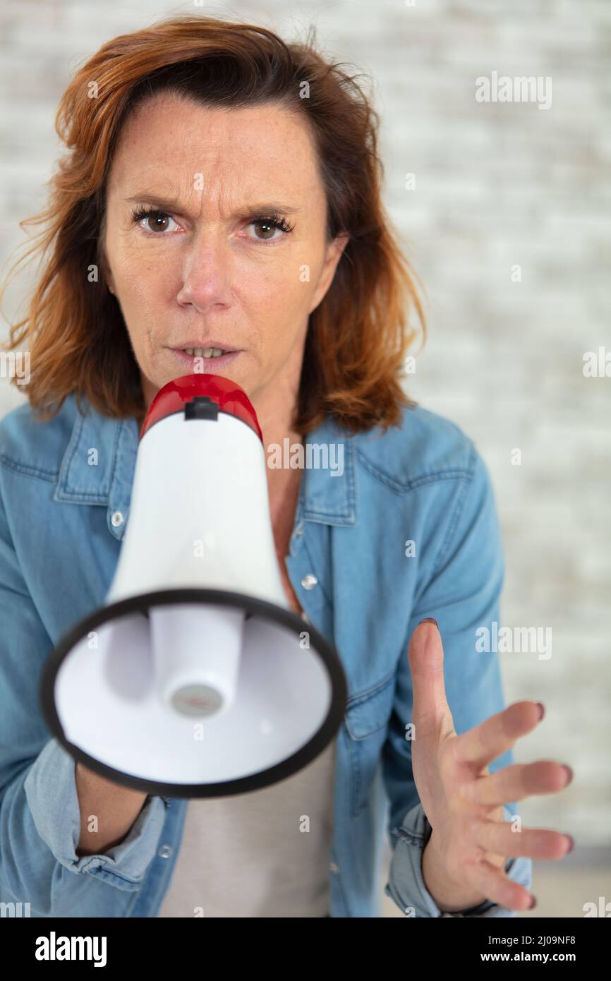 insistent older woman talking through megaphone Stock Photo - Alamy