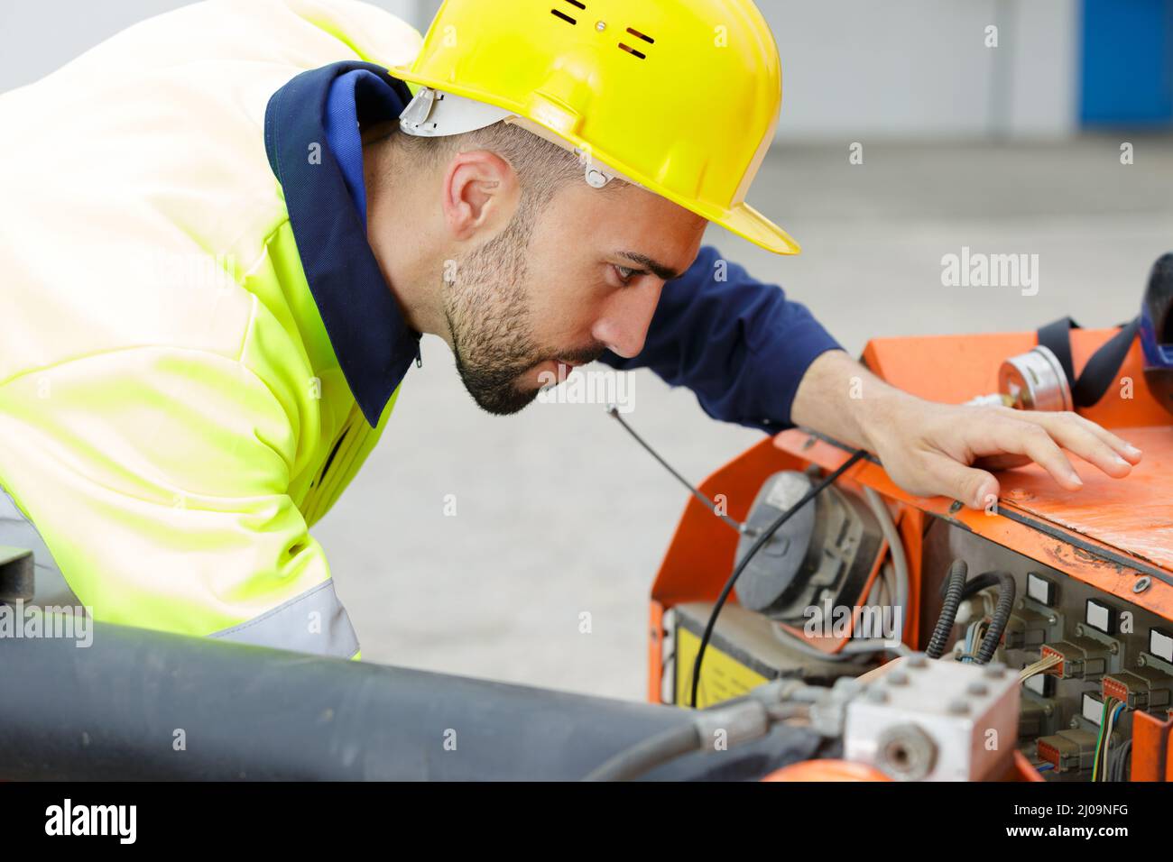 workman starting generator on outdoor site Stock Photo - Alamy