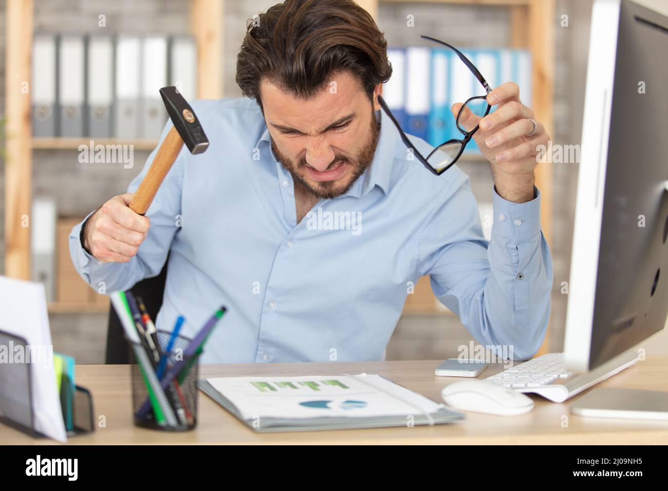 furious businessman destroying his laptop with a hammer Stock Photo - Alamy