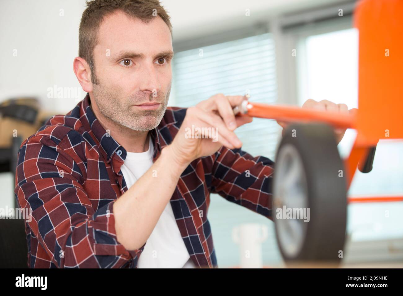 engineer repairing wheel on a sack truck Stock Photo - Alamy