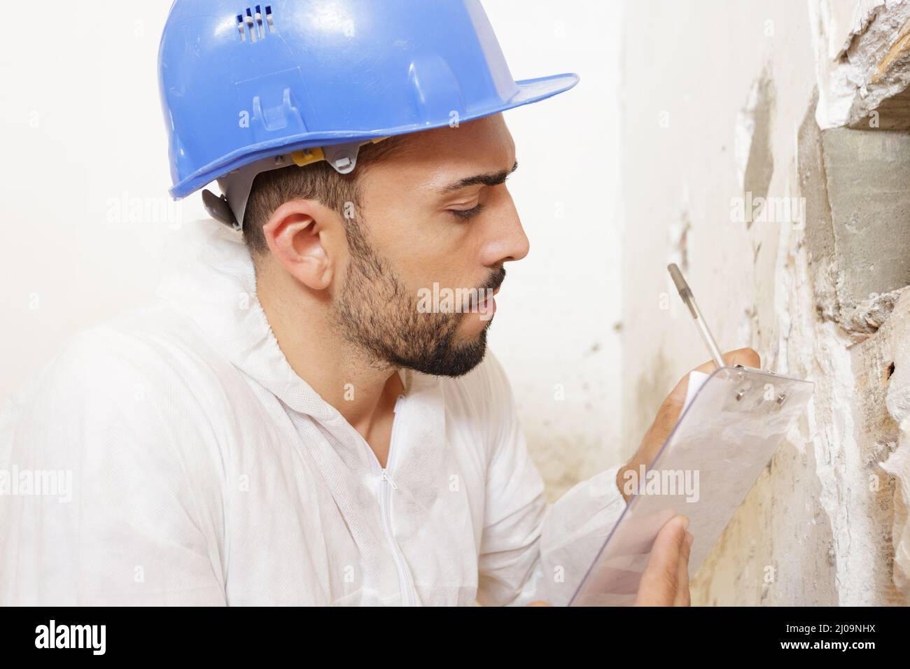 construction worker wearing helmet taking notes on clipboard Stock ...
