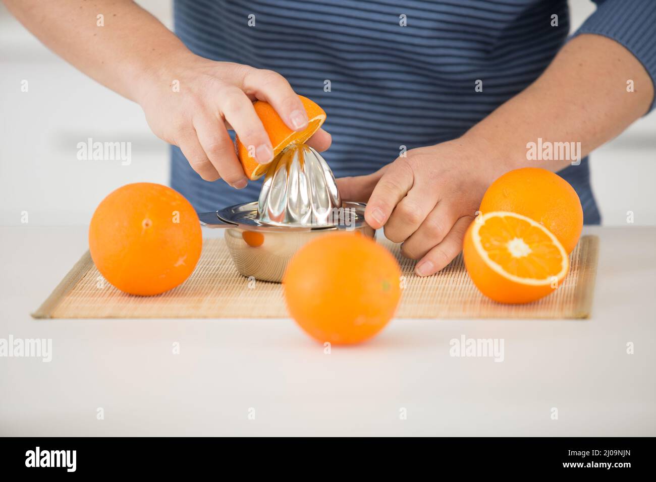 squeezing orange fruit and making juice Stock Photo - Alamy