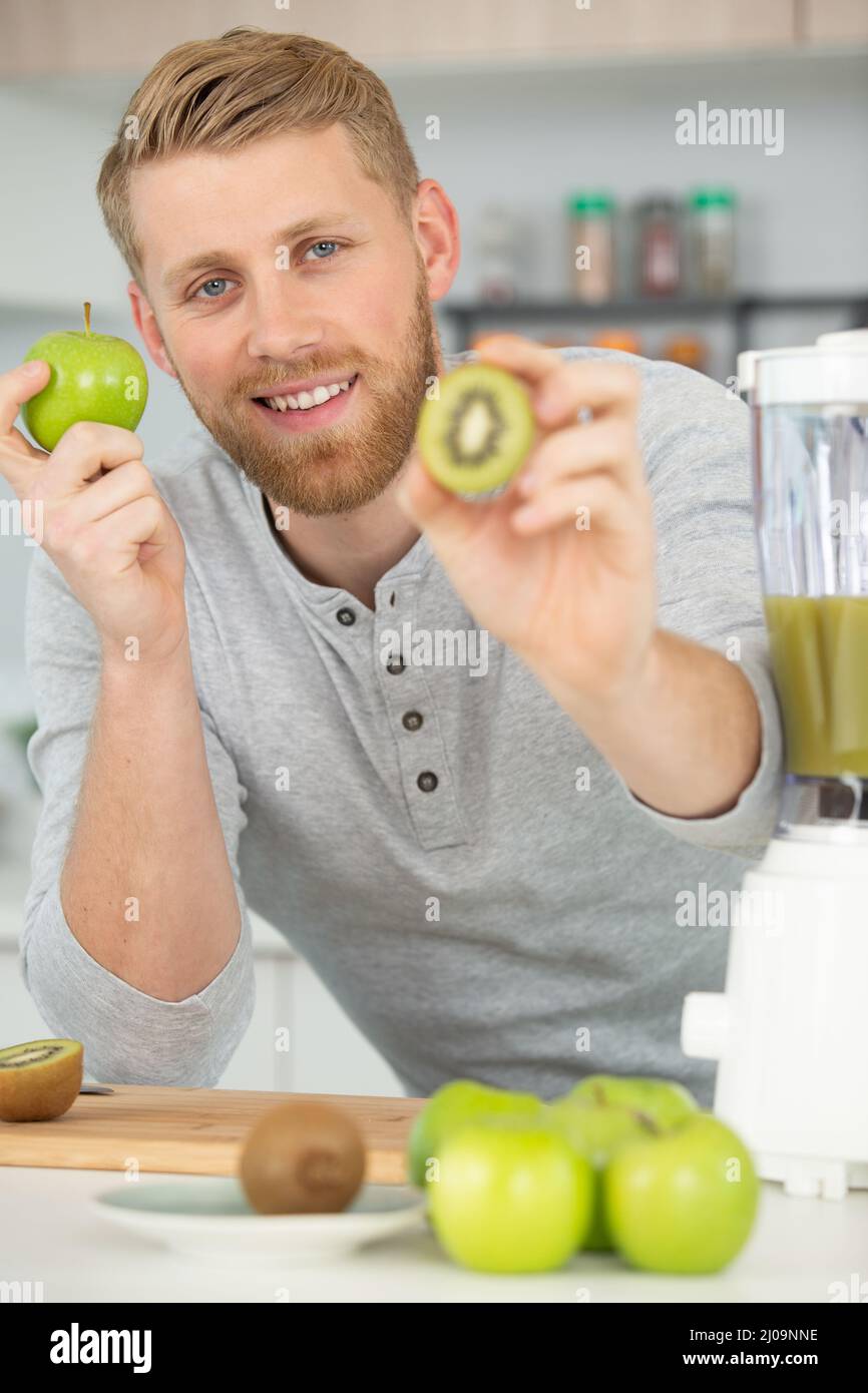 happy man making juice or smoothie in kitchen Stock Photo - Alamy