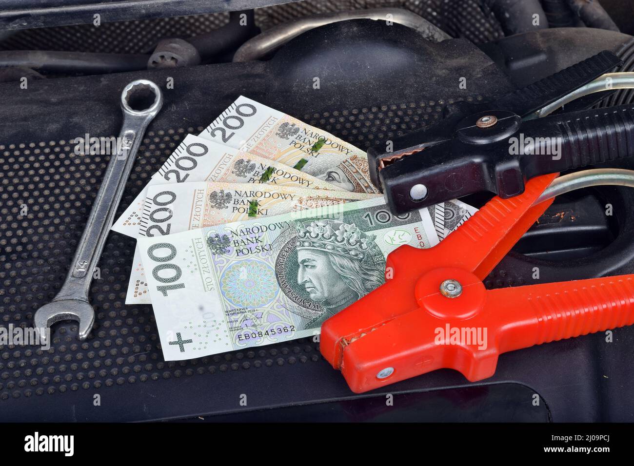 Polish money currency and ring spanner and electricity jumper cables to ...