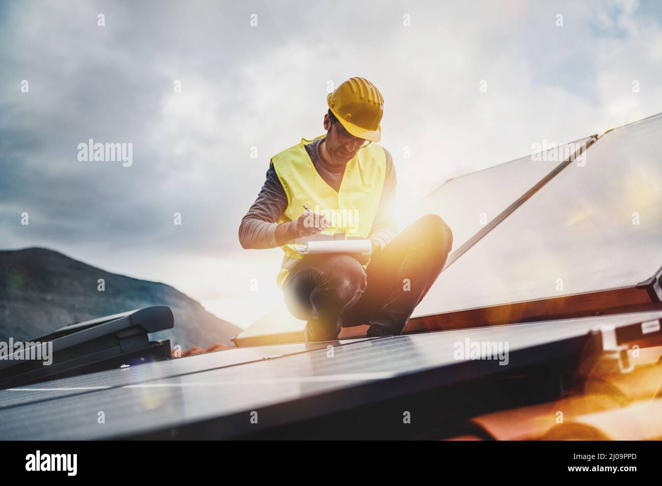 Man works on renewable energy system with solar panel for electricity ...