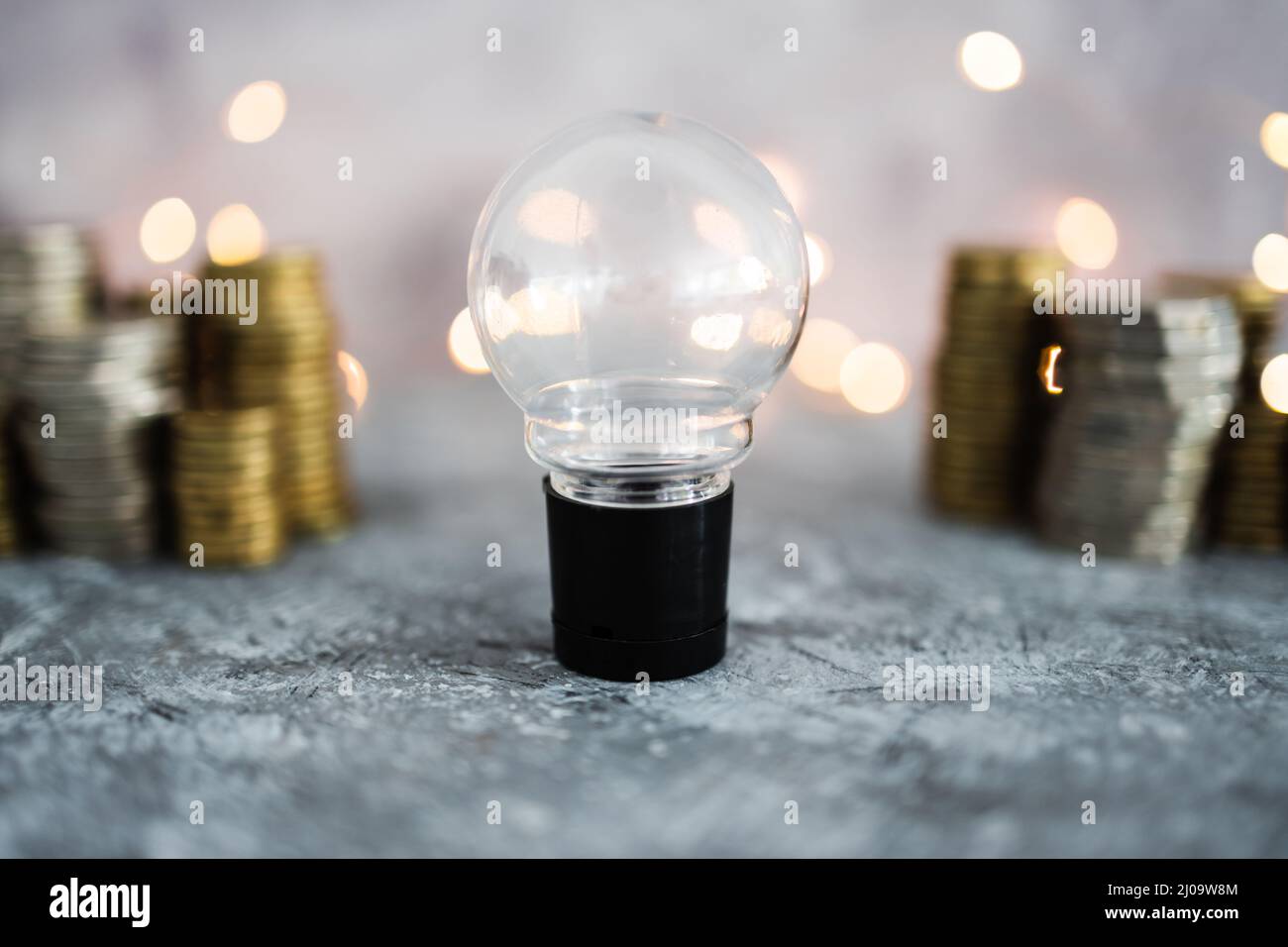 idea light bulb with stacks of different golden and silver coins ...