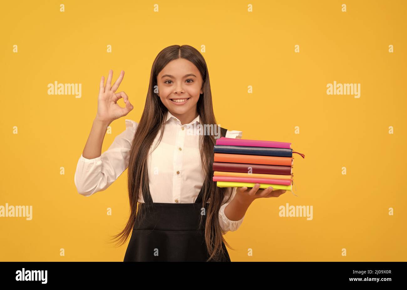 bookish kid in grammar school. happy teen girl hold books heap. perfect ...