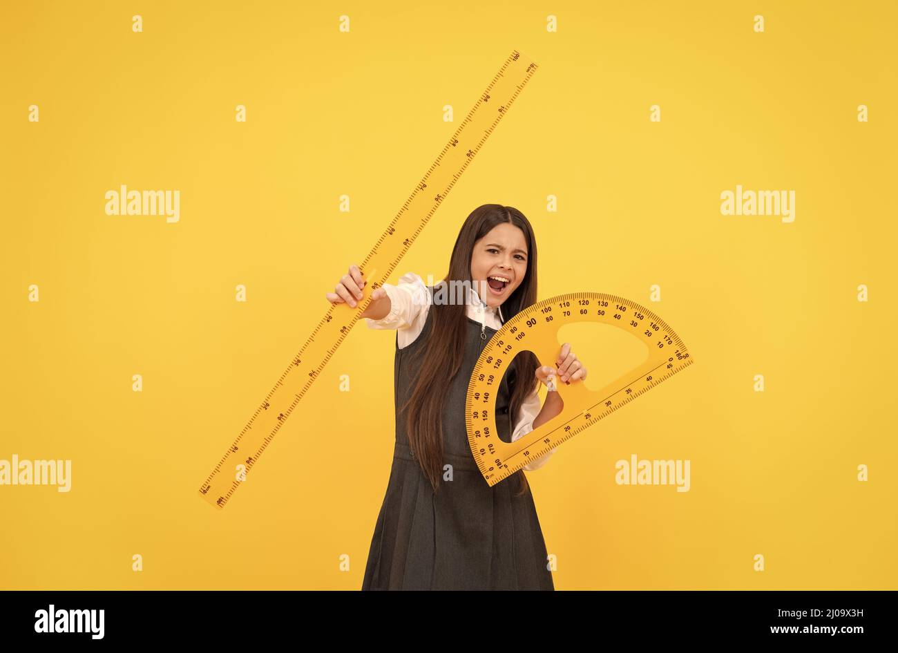 emotional child hold math protractor and ruler in school on yellow ...
