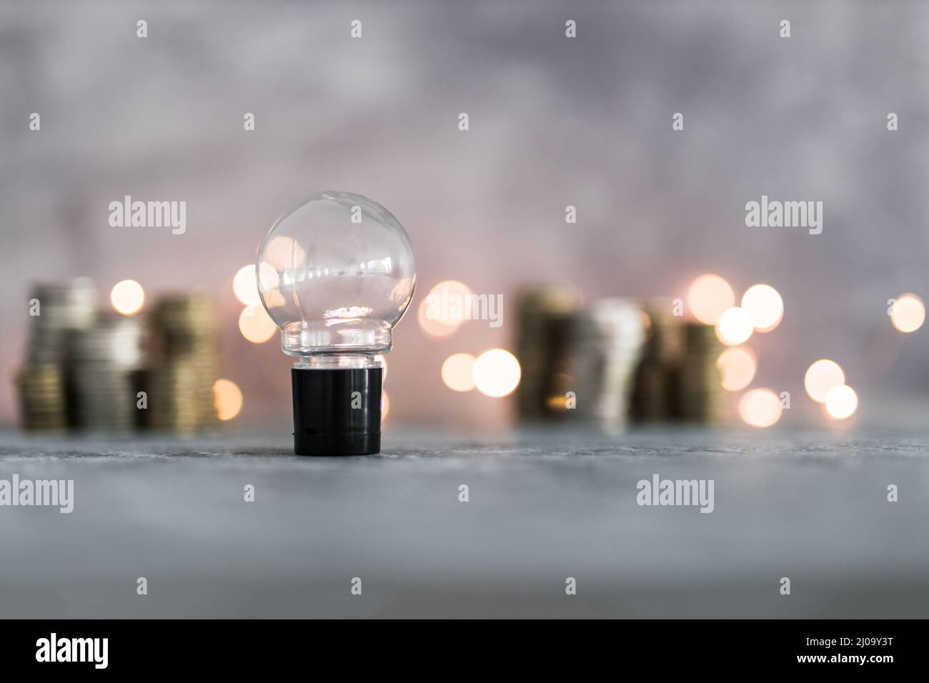 idea light bulb with stacks of different golden and silver coins ...