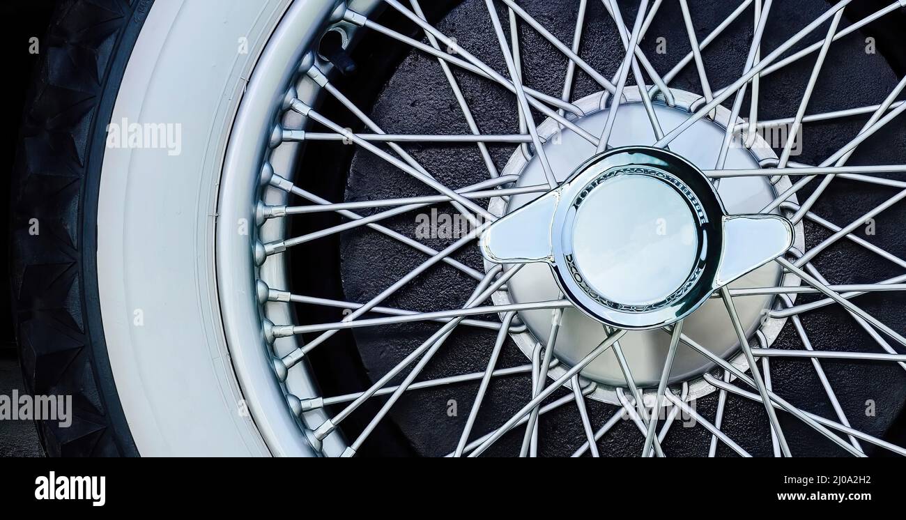 Antique chrome spoke wheel with white-faced rubber and center nut Stock ...